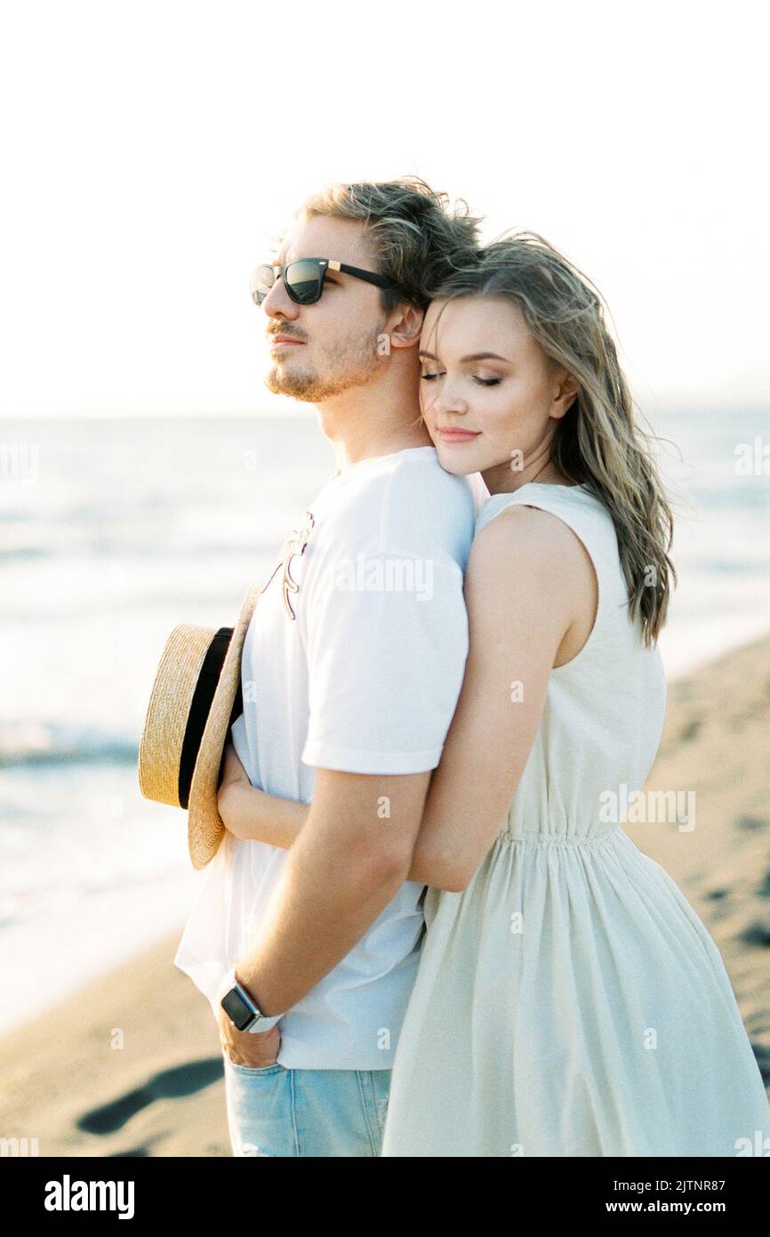 Woman Hugging Man From Behind While Standing On The Beach By The Sea