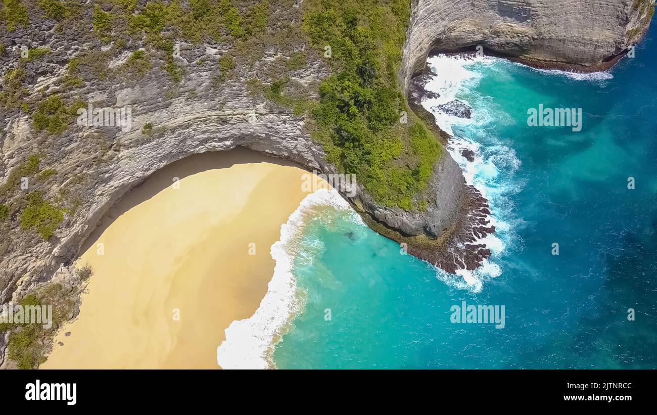 Nusa Penida Island, Kelingking Beach. Top view aerial view of a sandy clean beach with clear ...