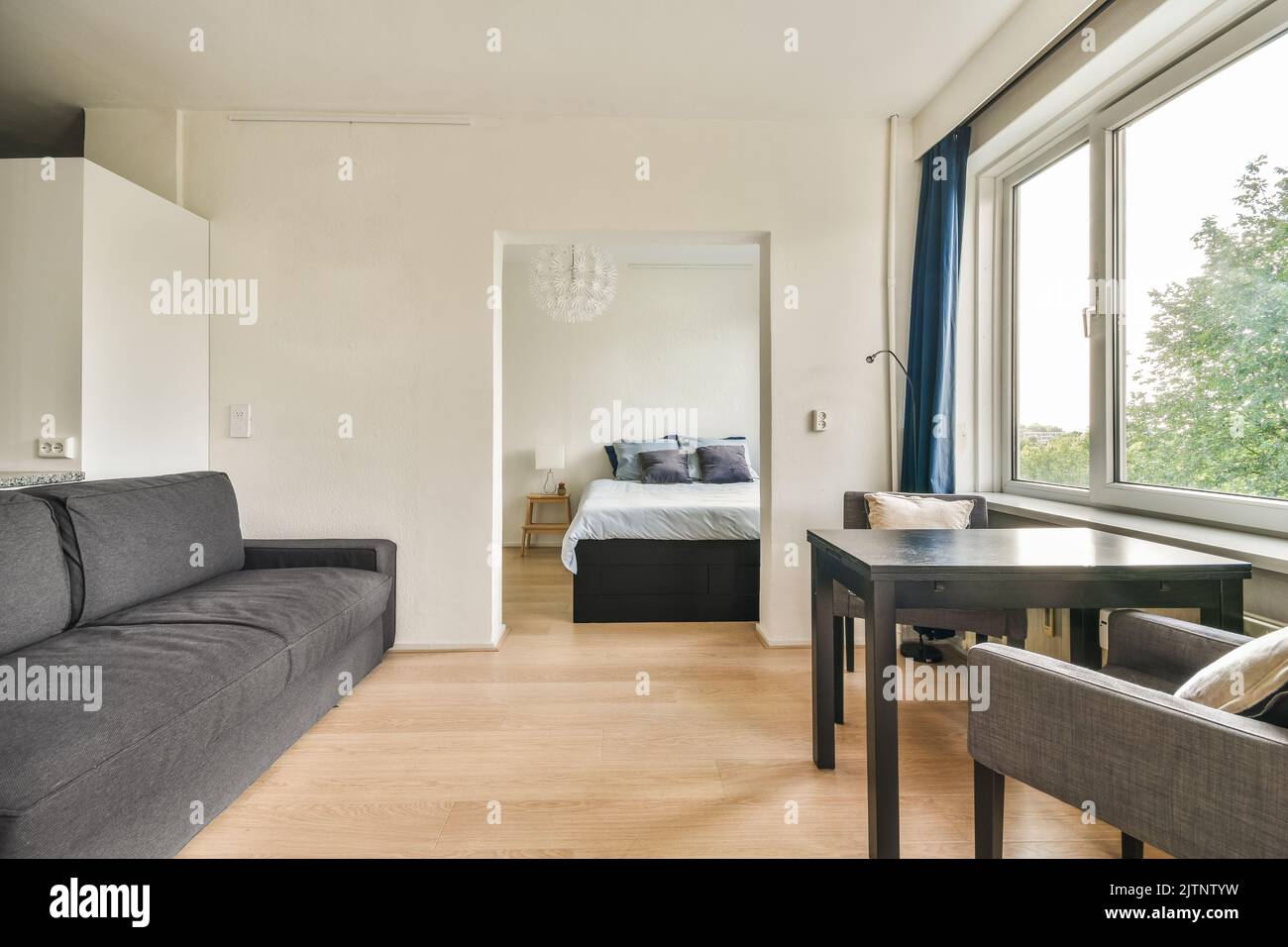 Interior of light room with stylish dining and lounge areas in modern ...