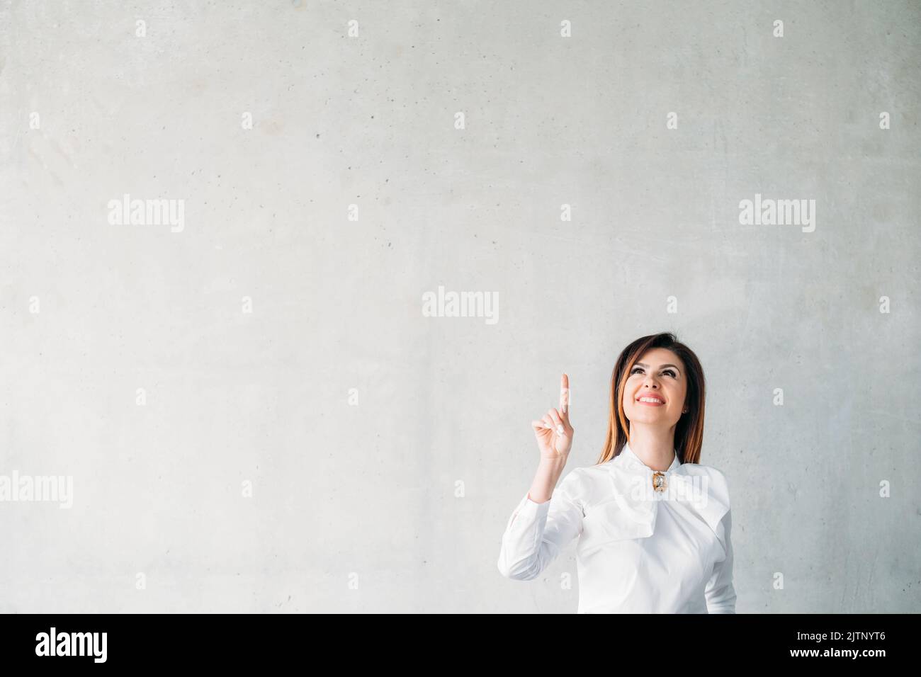 beautiful young woman pointing up advertisement Stock Photo - Alamy