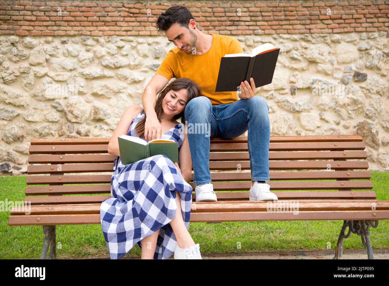 Couple reading books together in a park while sitting on a bench Stock ...