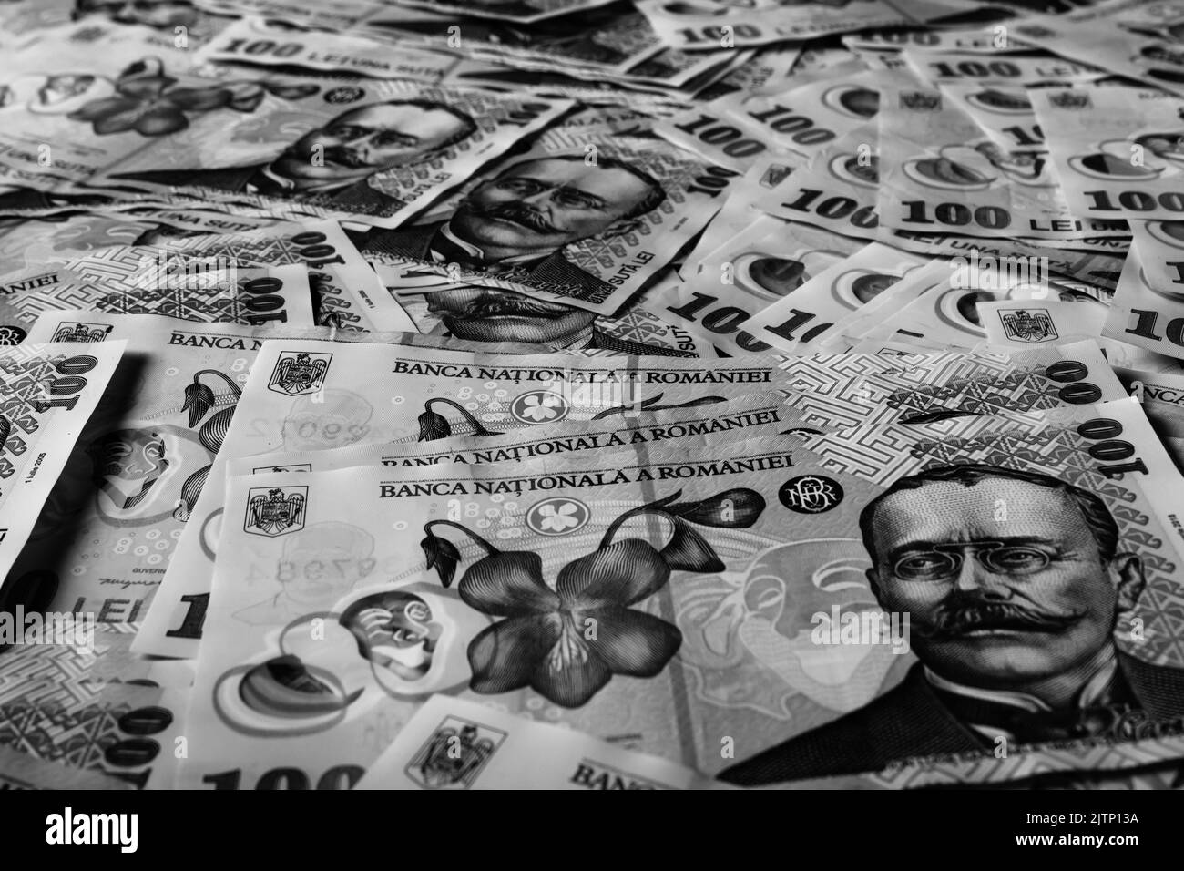 A grayscale closeup shot of a large pile of 100 Romanian leu banknotes ...