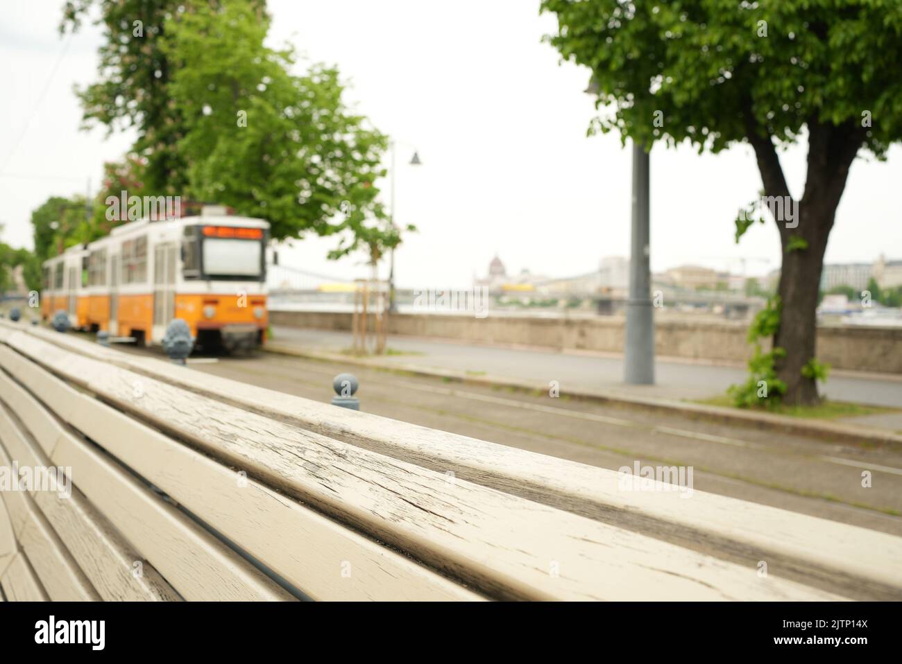 Yellow tram approaching next to river Stock Photo - Alamy