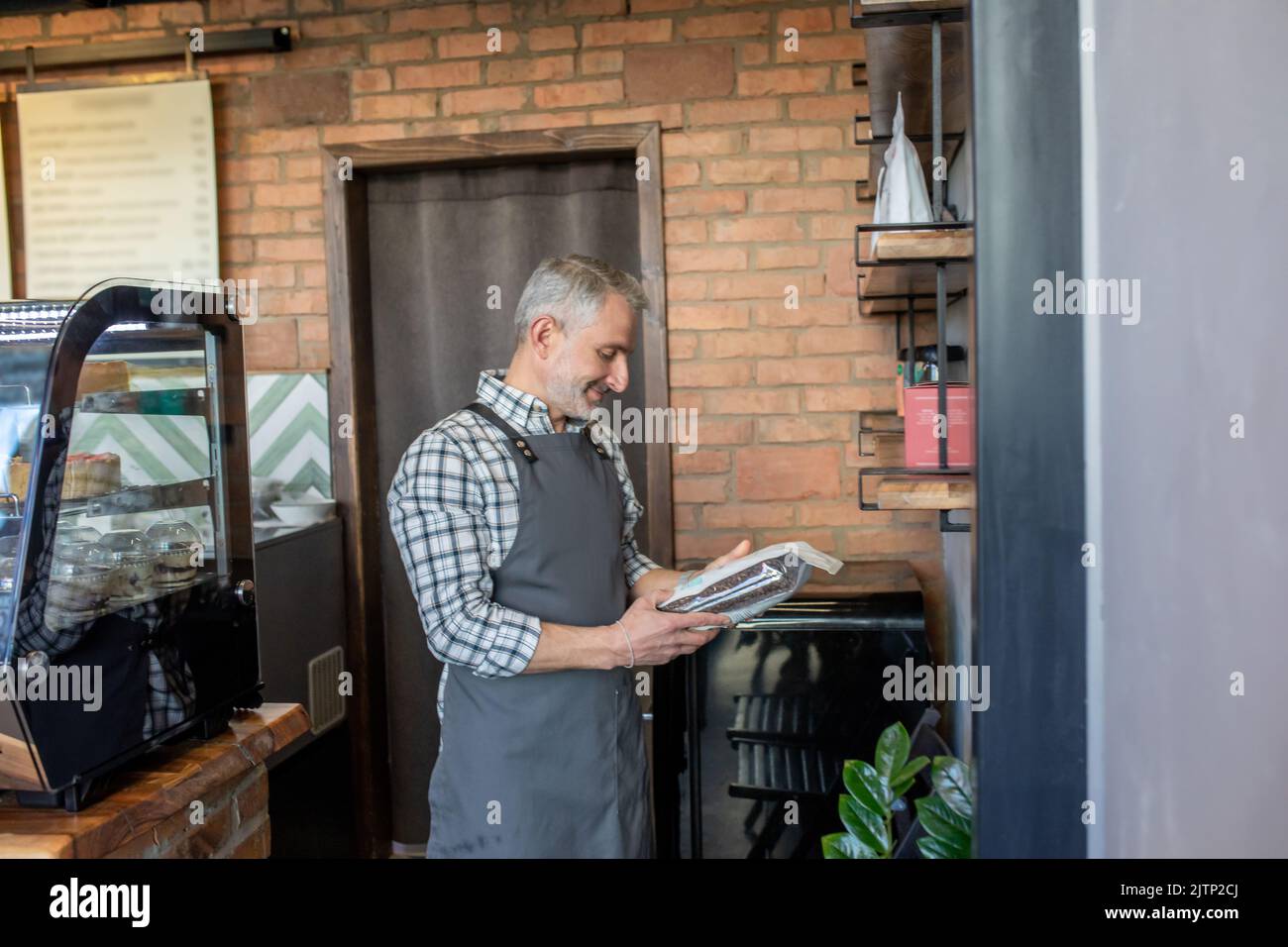 Cafe owner performing product quality control in his establishment ...