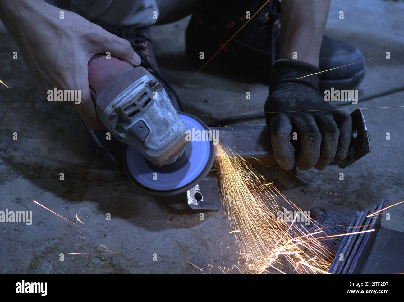 Worker grinding metal with grinding machine. Sparks when grinding iron ...