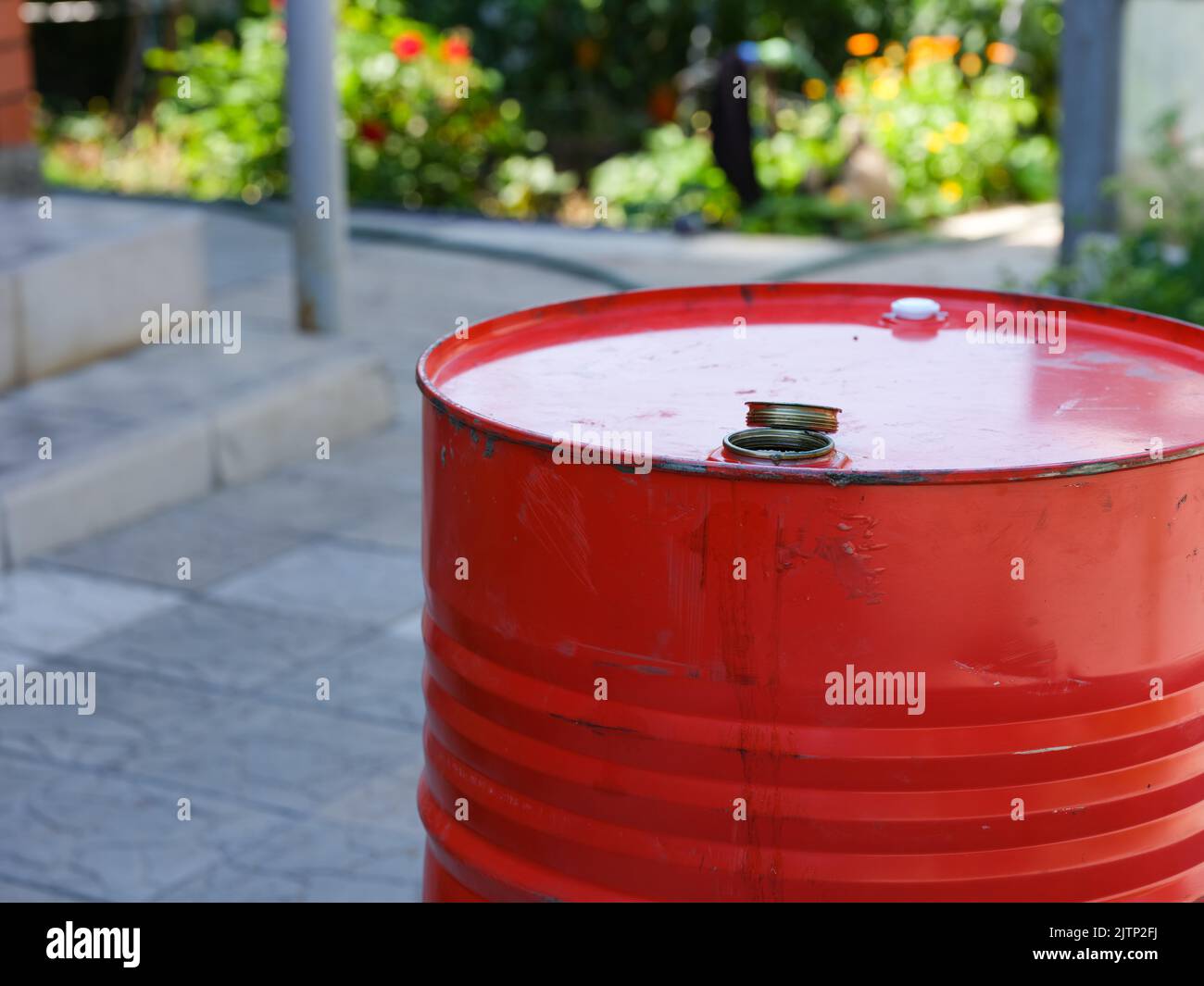 A red metal barrel standing in a yard Stock Photo - Alamy