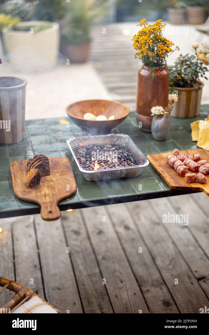 Cooking food on disposable grill at backyard Stock Photo - Alamy
