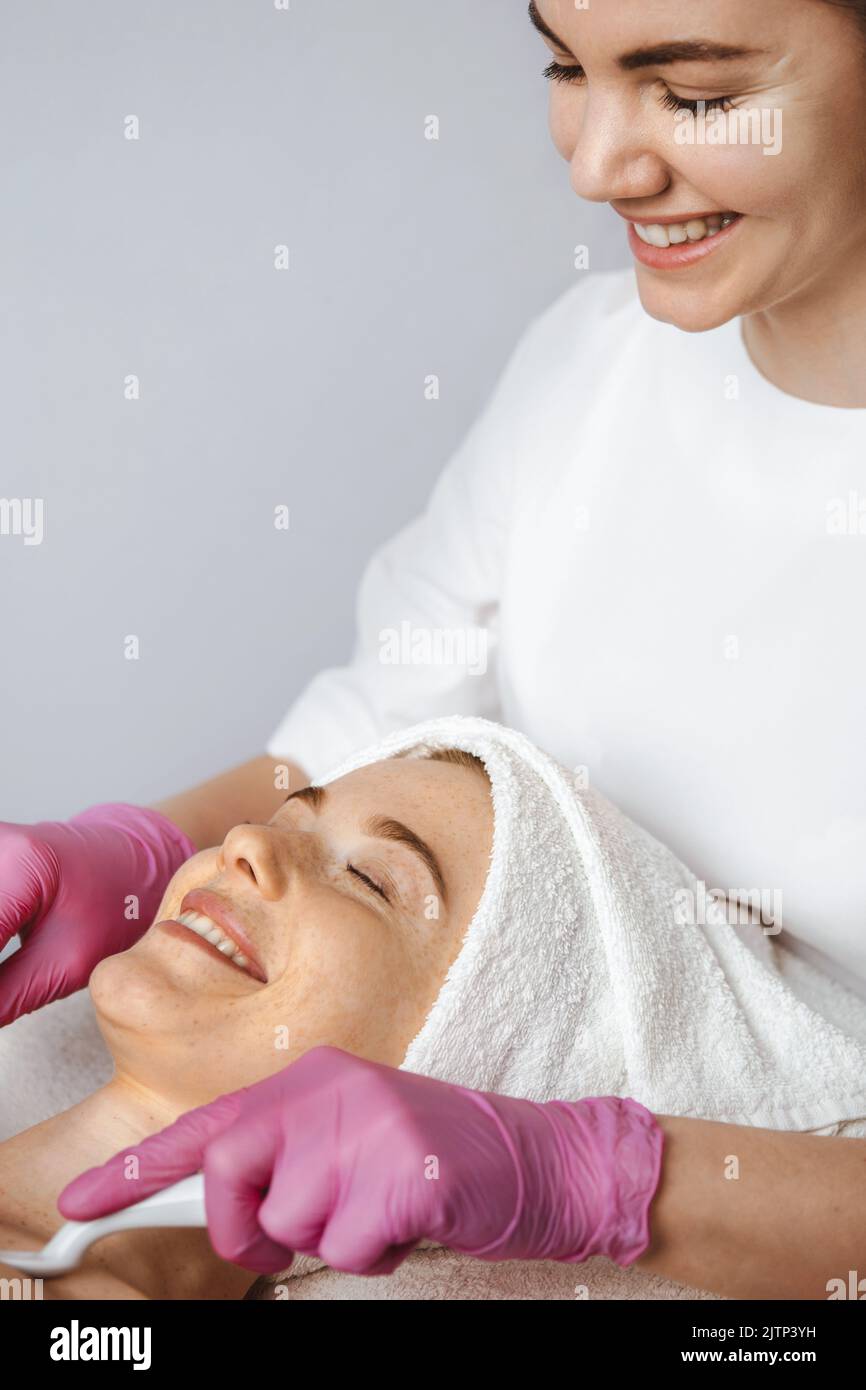 Freckled caucasian woman with closed eyes receiving chest massage with ...