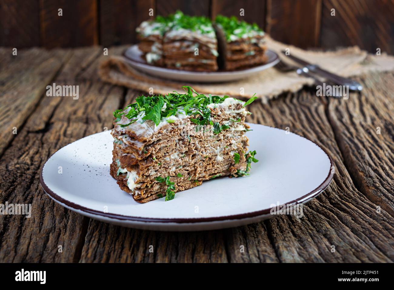 Liver cake on wooden background. Sliced layered liver cake with ...