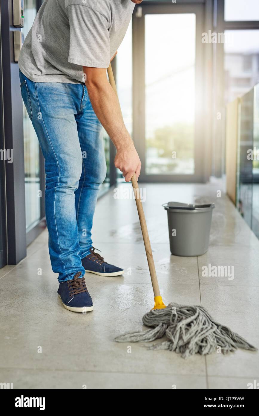 You wont find a cleaner floor. an unrecognizable man mopping the office ...