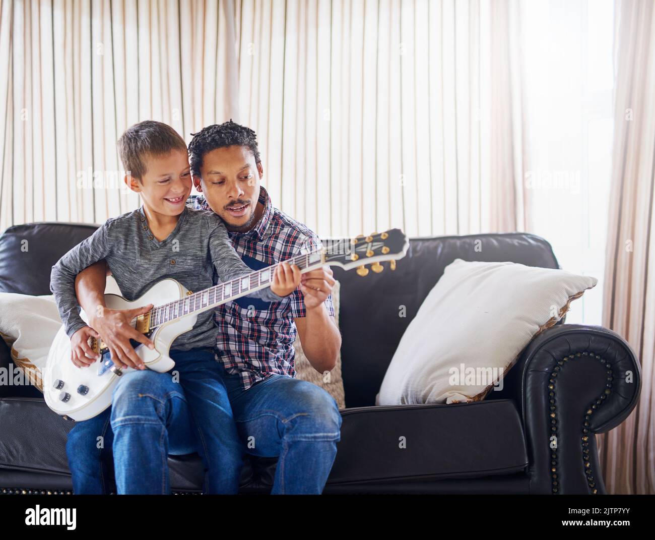 Teaching his son a new tune. a father teaching his son how to play ...