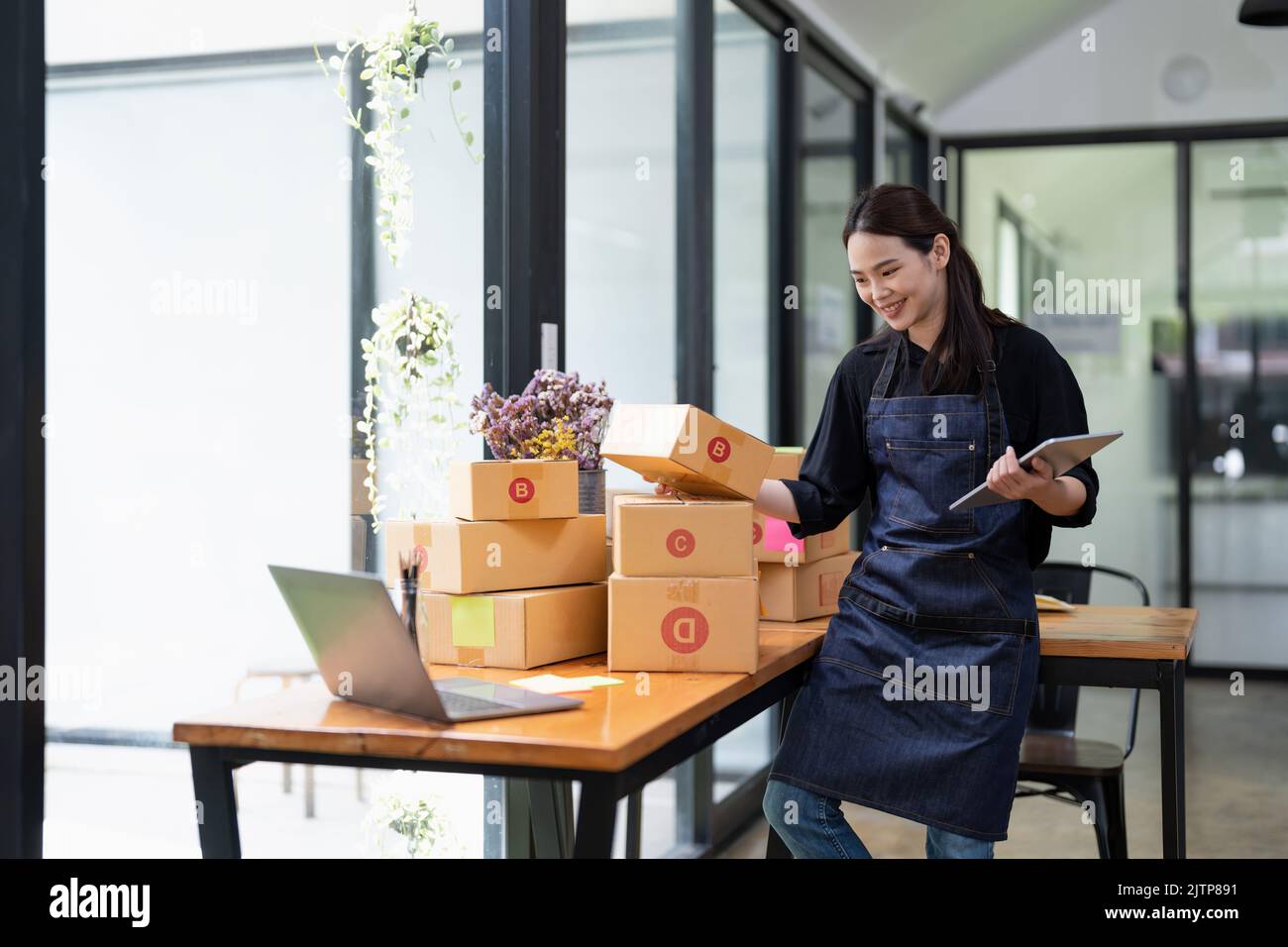 Young attractive asian woman owner startup business with box at home ...