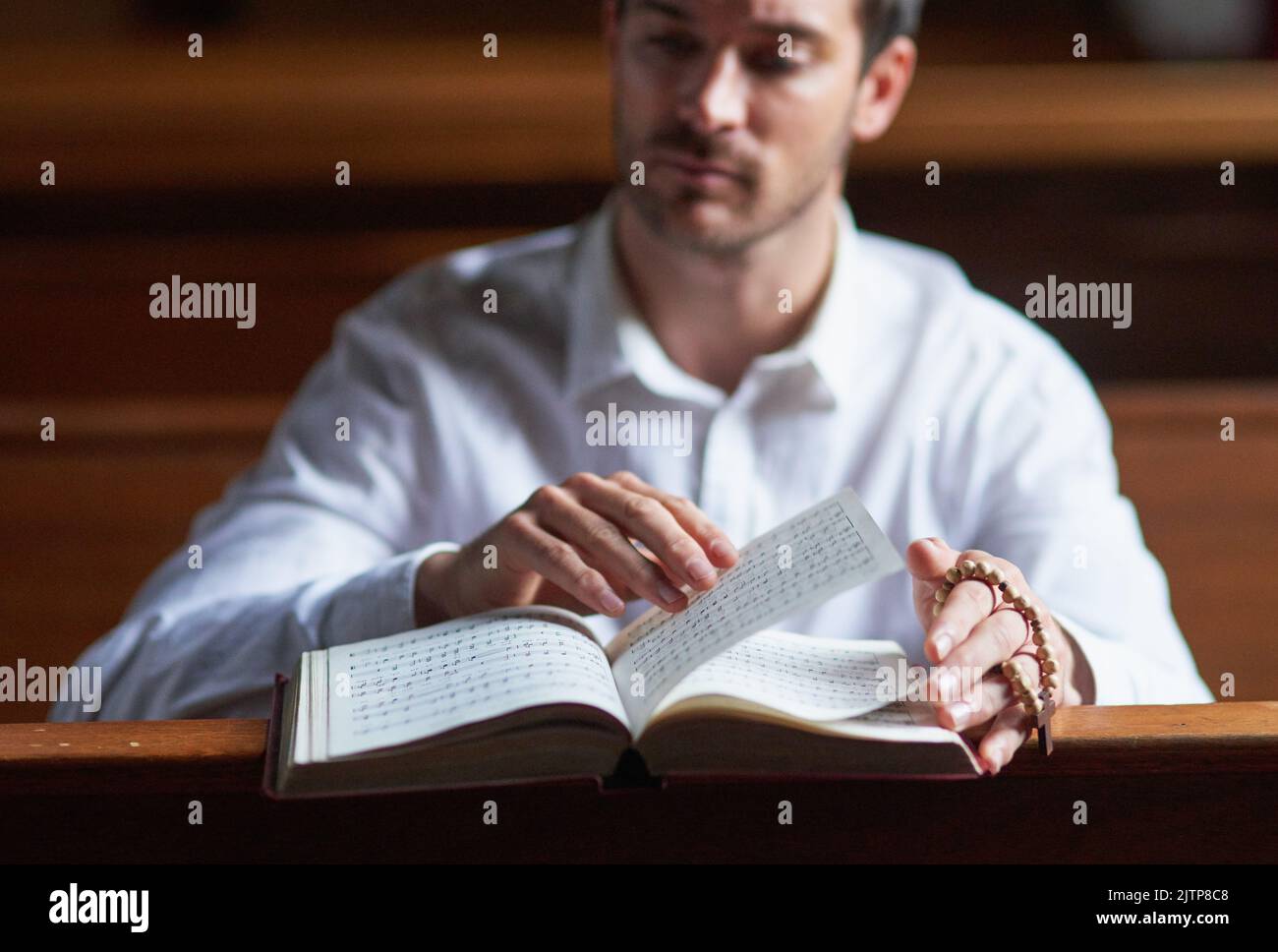 Theres a reason why its a bestseller. a young man reading the bible in ...