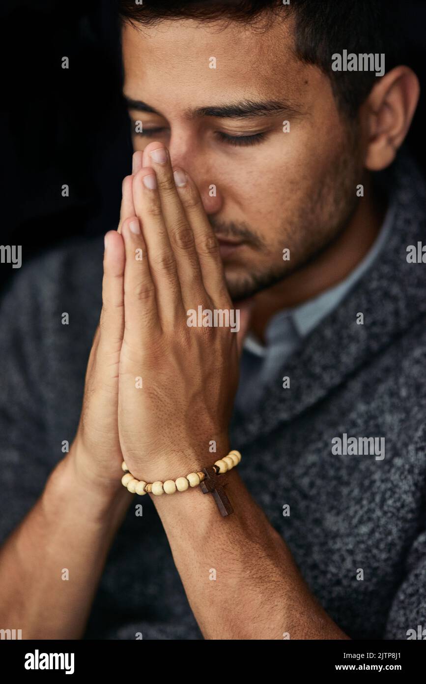 Give us this day our daily bread. Closeup shot of a young man praying ...
