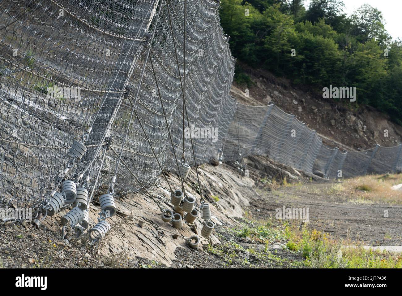 Active robust rockfall barrier system with wire mesh along the road ...