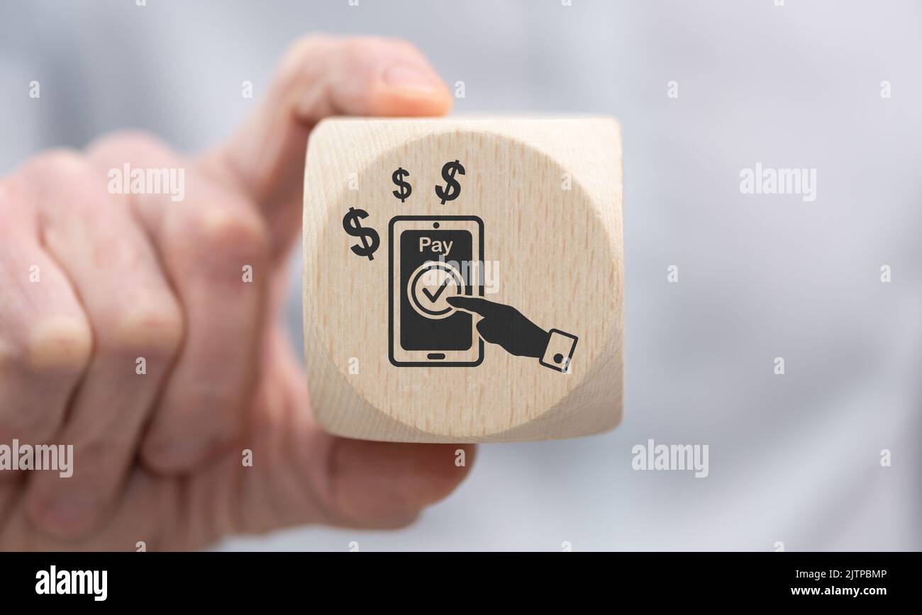 Hand holding a wooden cube with symbol of mobile payment concept Stock ...