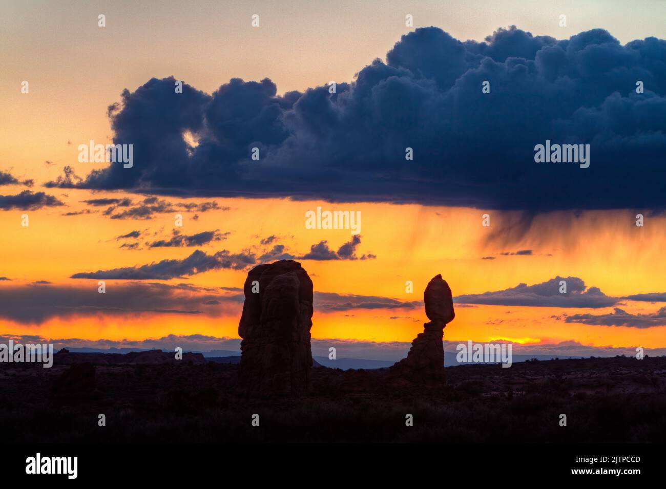 Sunset silhouette of Balanced Rock with virga from a rainstorm over ...