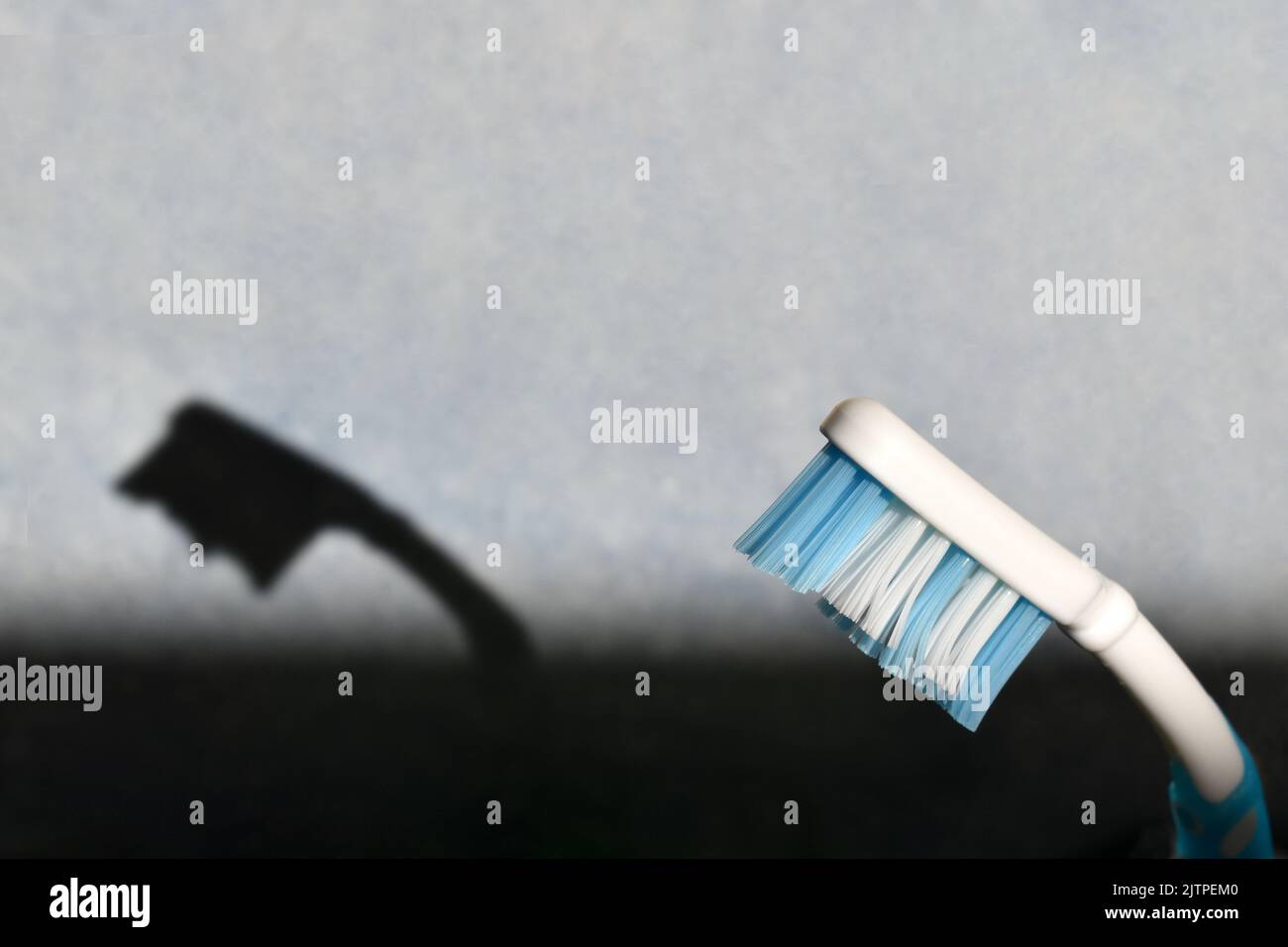 Old toothbrush with shadow in a bathroom Stock Photo - Alamy