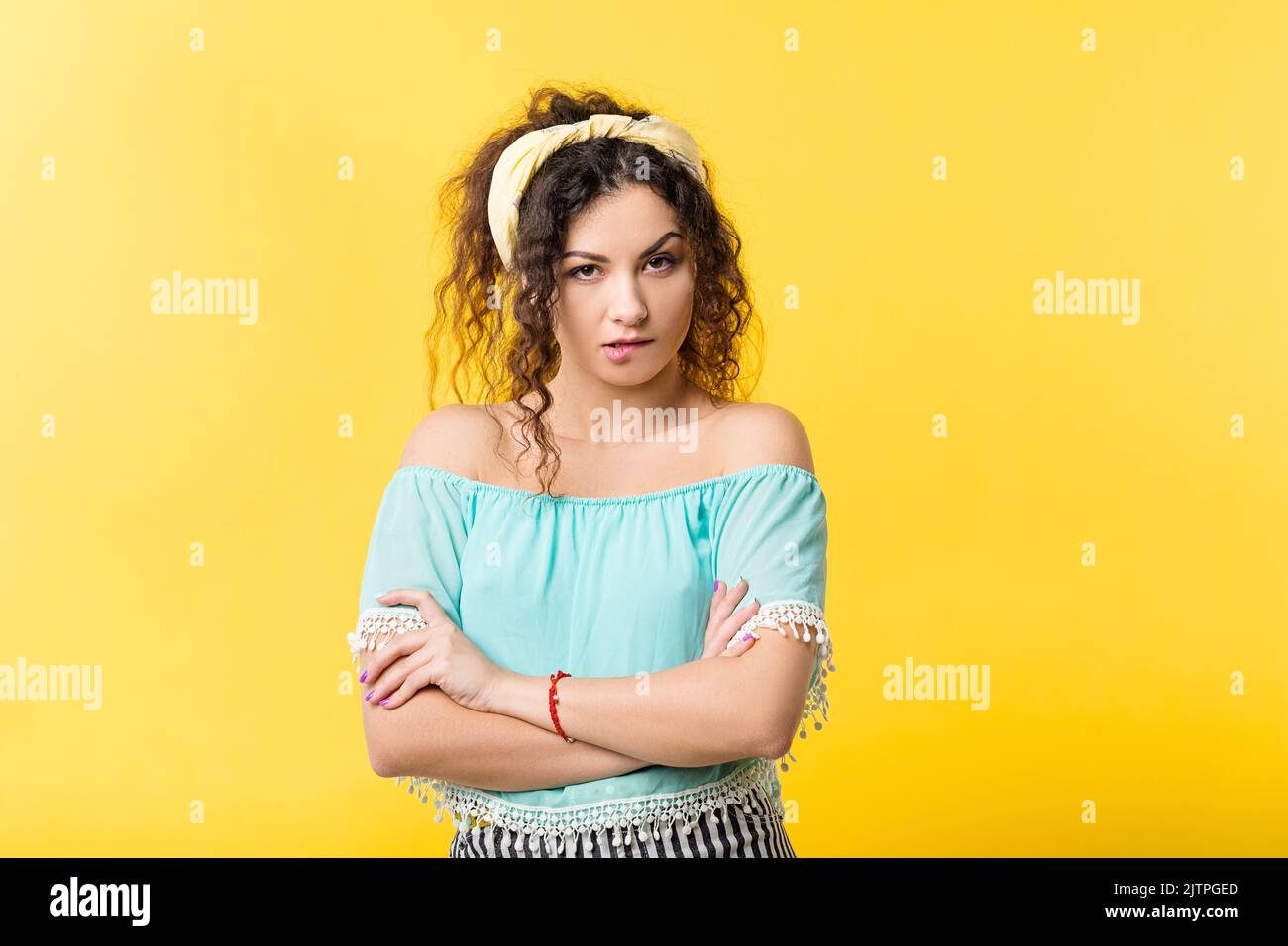 young woman fixed gaze crossed arms skeptical Stock Photo - Alamy