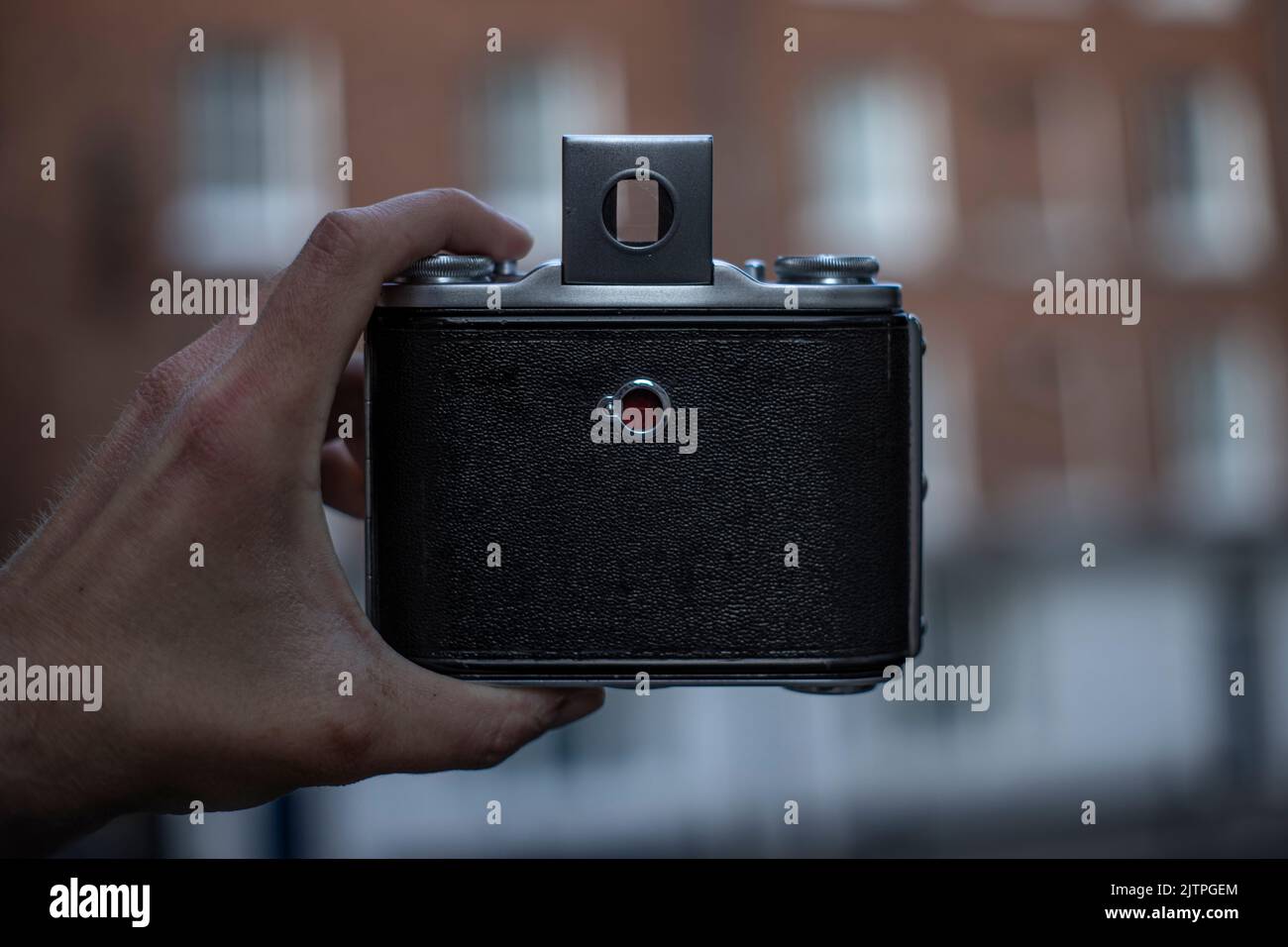 A Caucasian white man is holding an old vintage 35mm camera. Showing ...