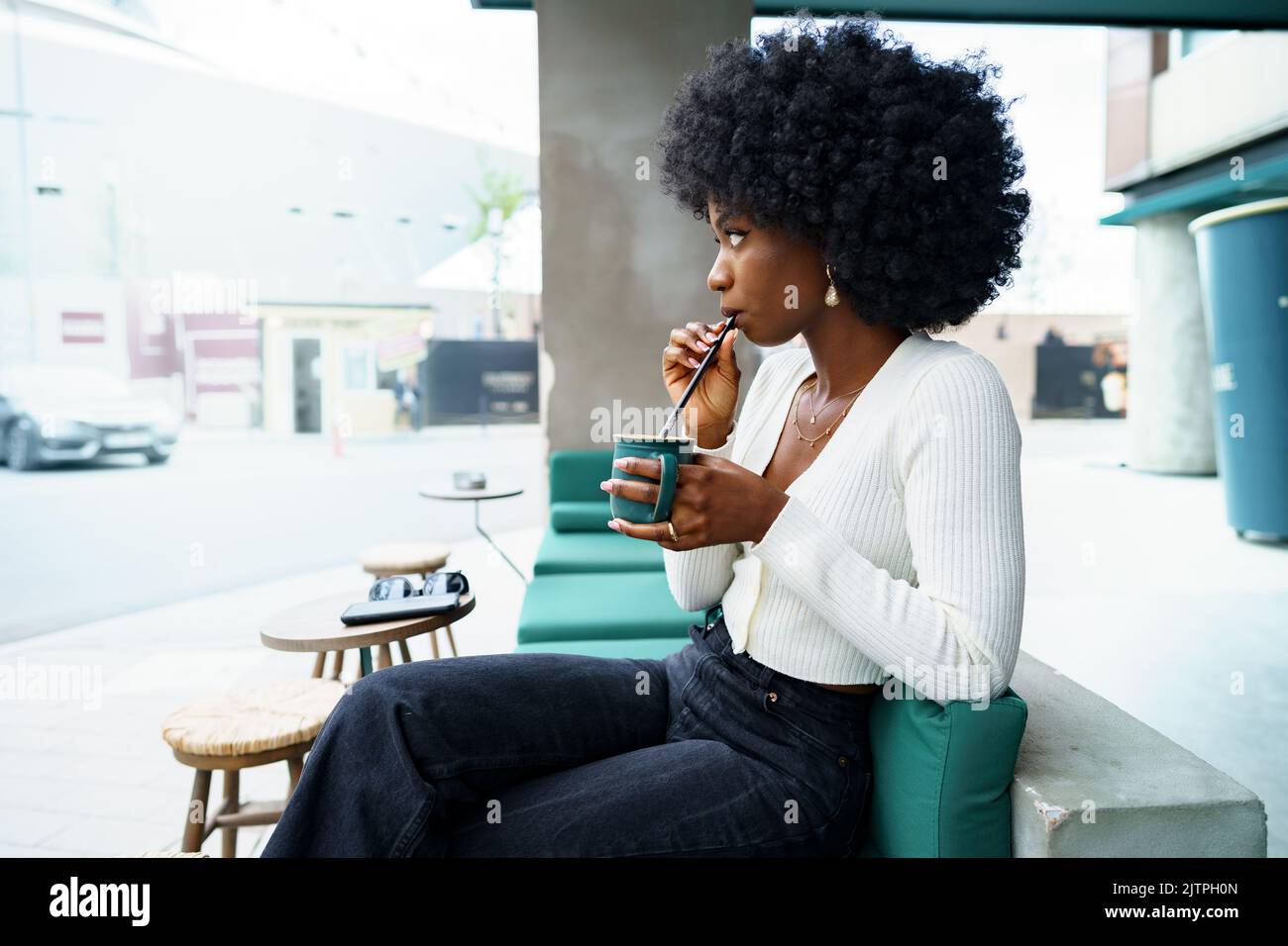 Young afro woman taking break and drinking coffee in cafe Stock Photo ...