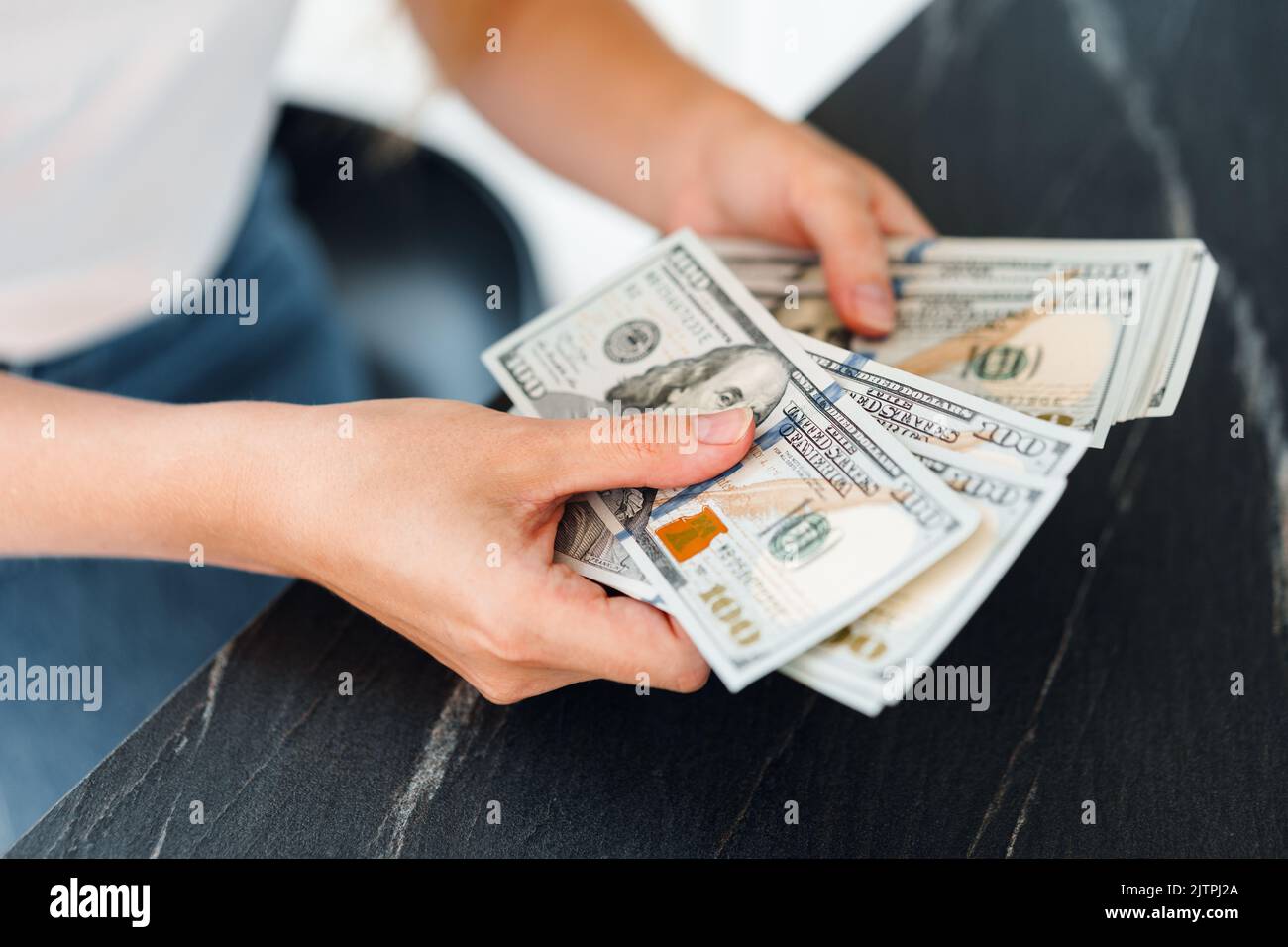 Woman counting dollar bills table hi-res stock photography and images ...