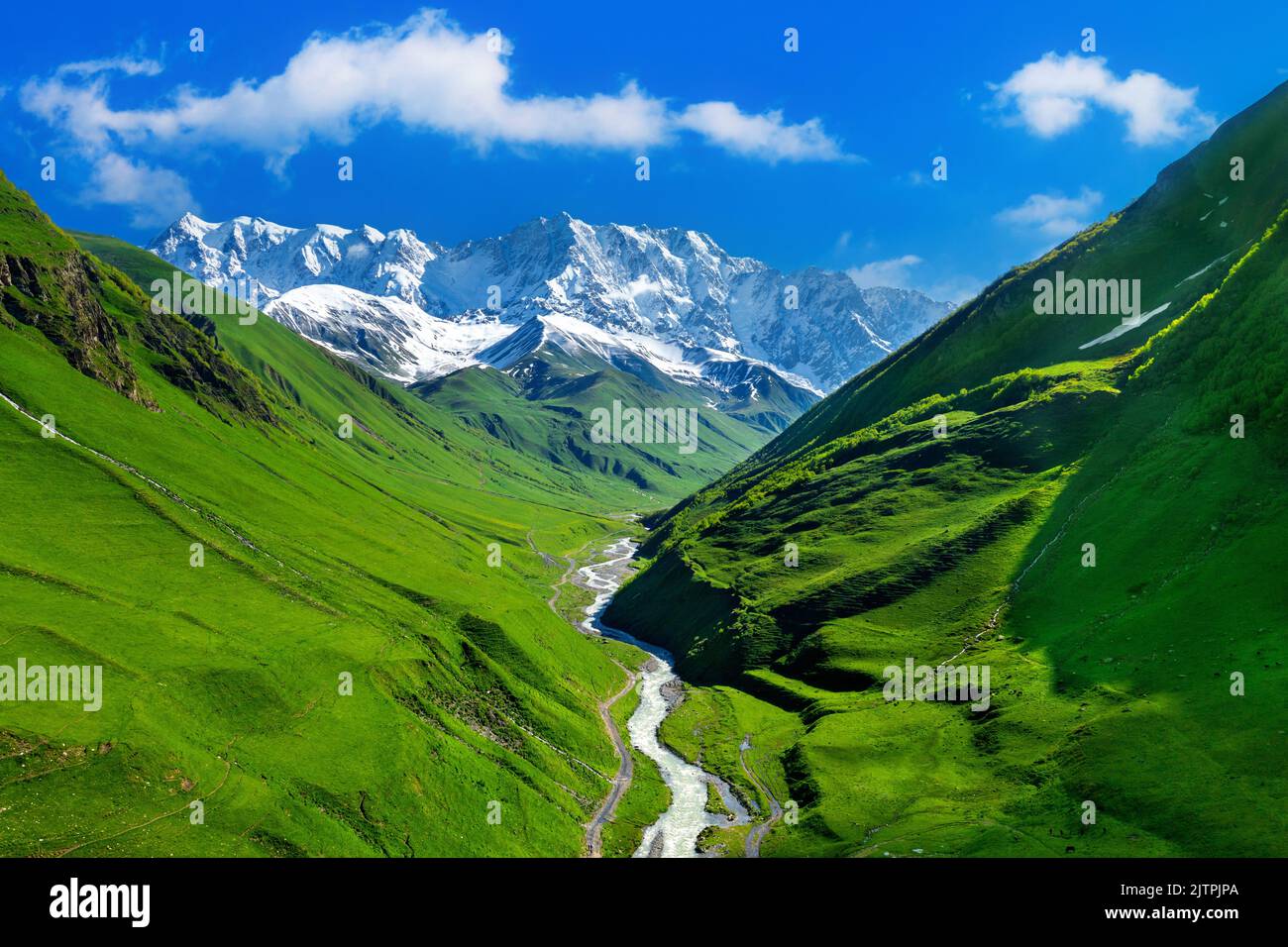 Green pasture and Patara enguri river against highest georgian mountain ...