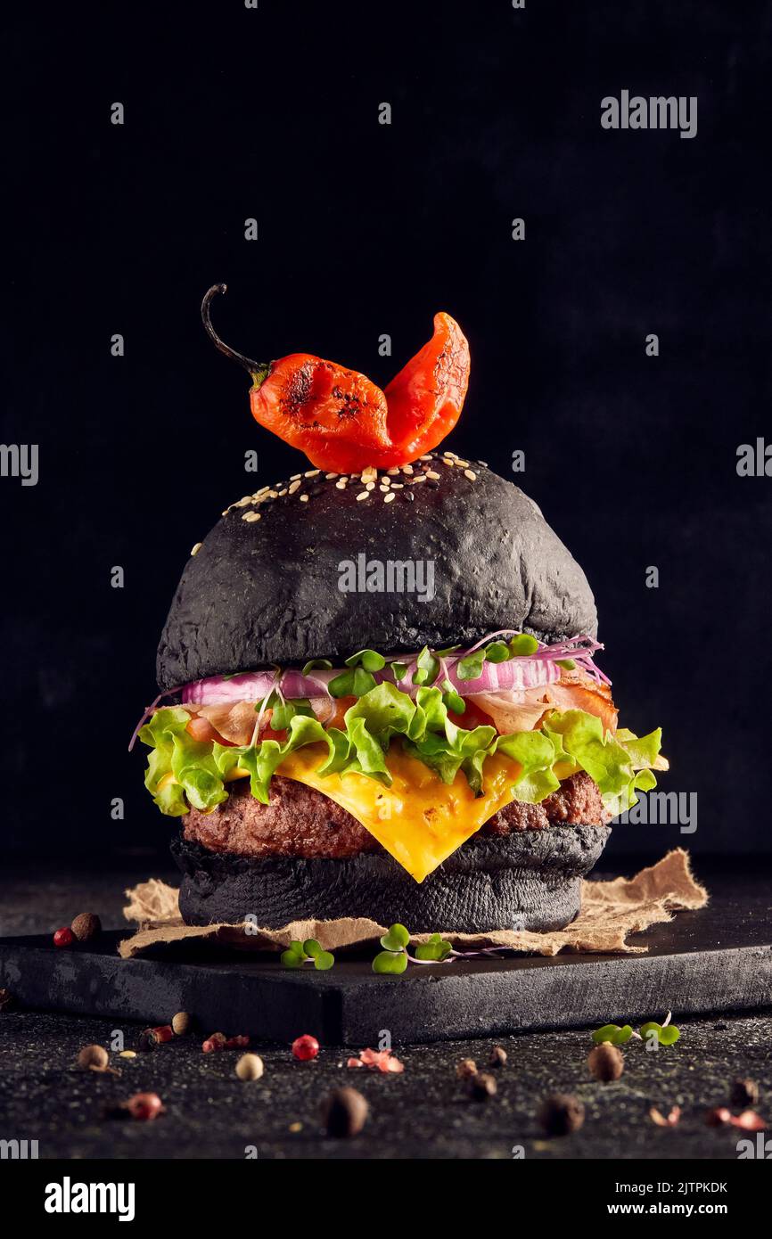 tasty spicy and dark burger over a wood table with pepper lettuce ...