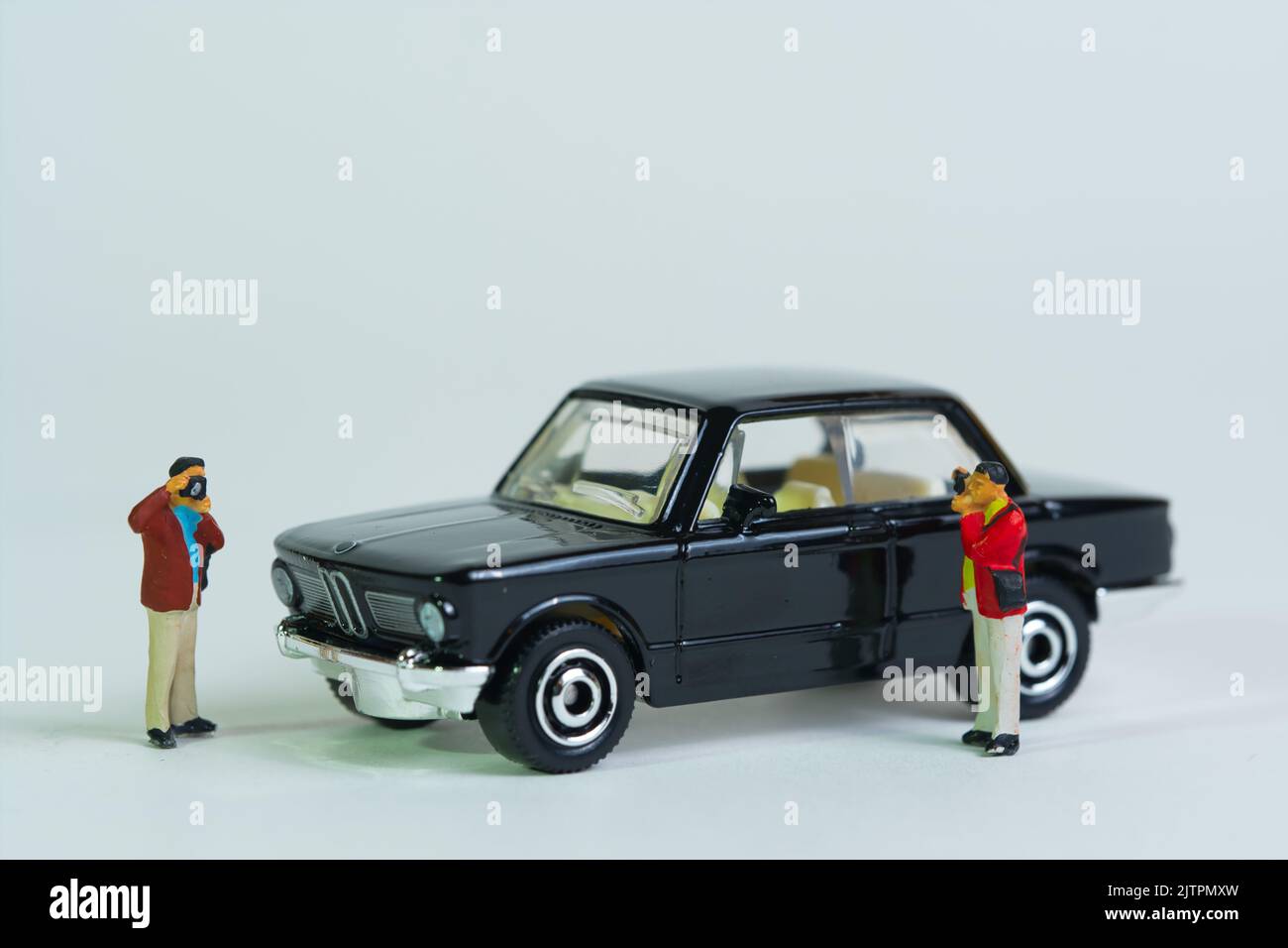 People take pictures of a black vintage car, miniature figures scene ...
