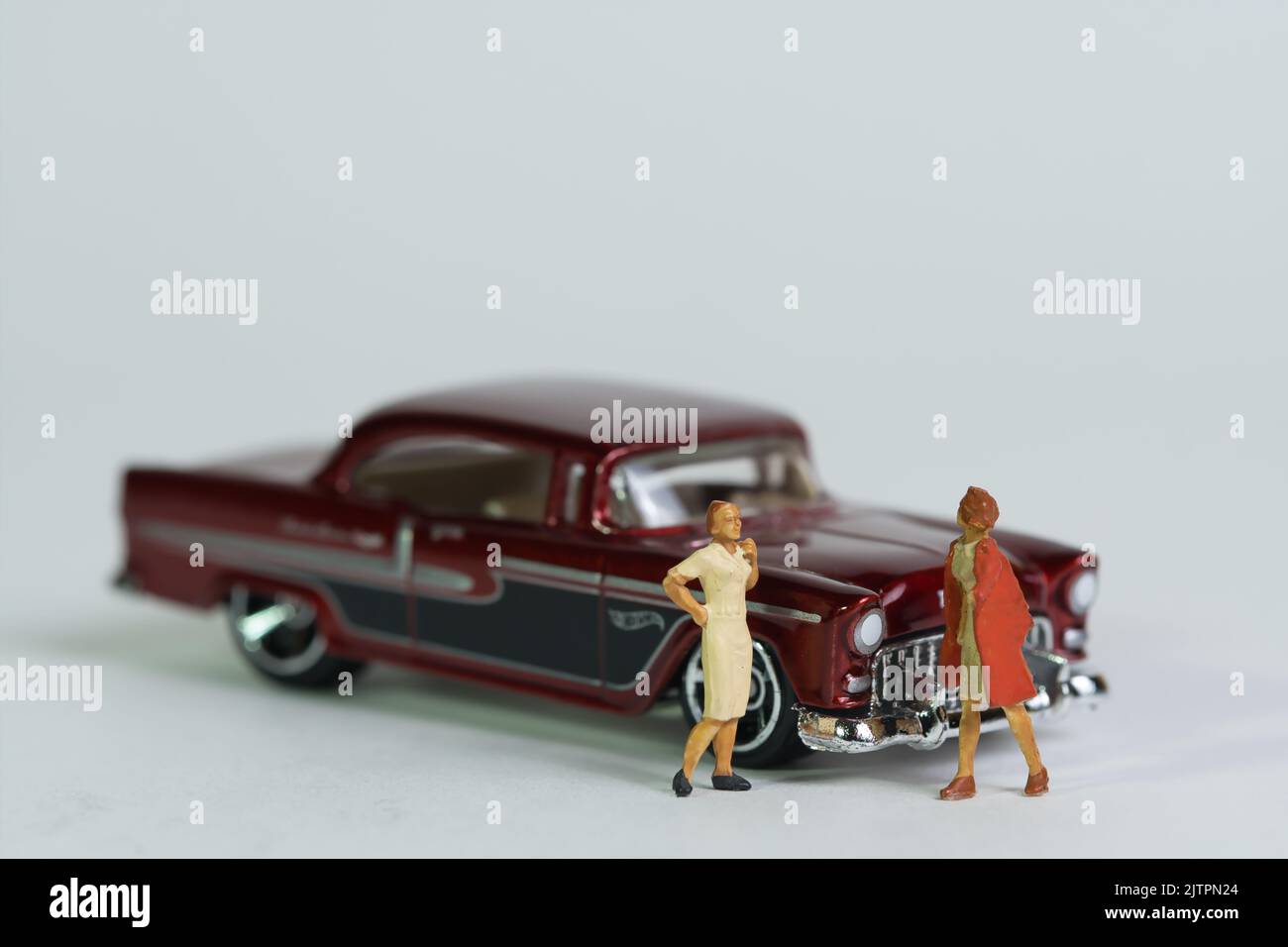 Woman standing in front of a vintage, retro car, miniature figures ...