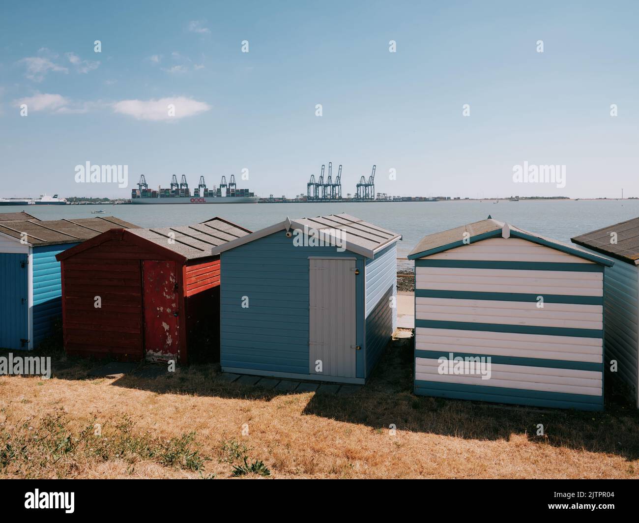 Painted beach huts on the seafront in Harwich looking across to the ...