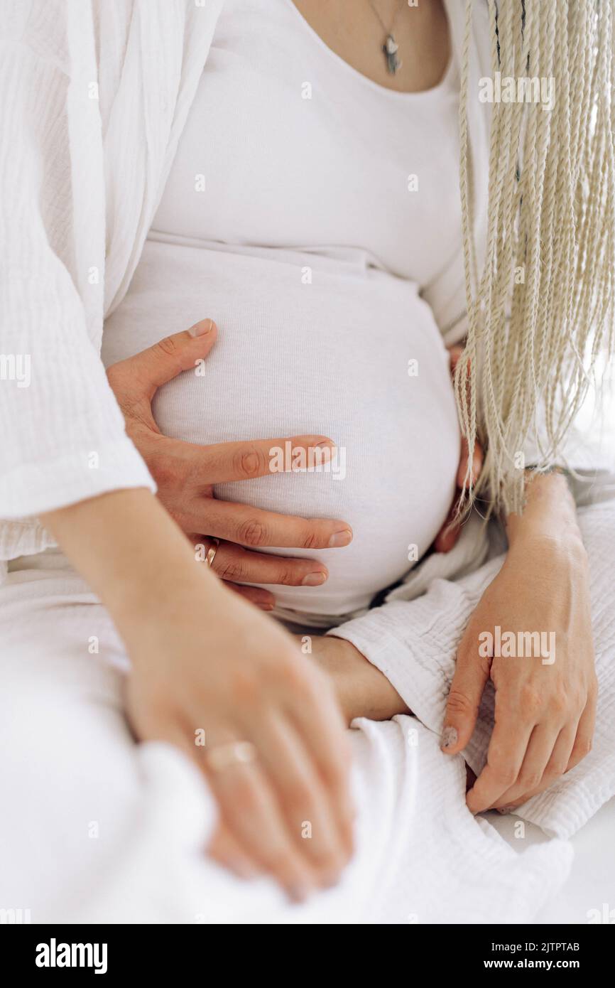 Couple parents tenderly touch pregnant belly by their hands. Concept of ...