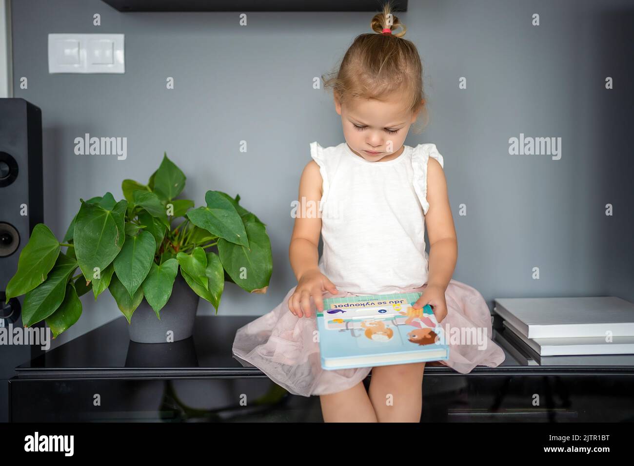 Adorable toddler little girl reading book at home. Happiness child ...
