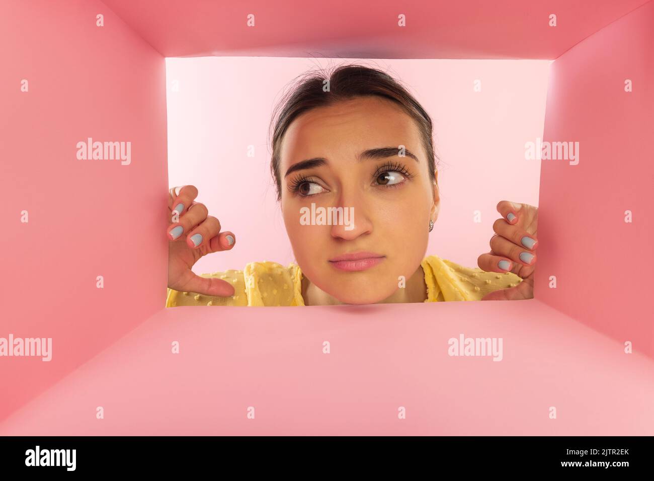 Sad, unhappy young woman looking inside empty cardboard box. Delivery ...