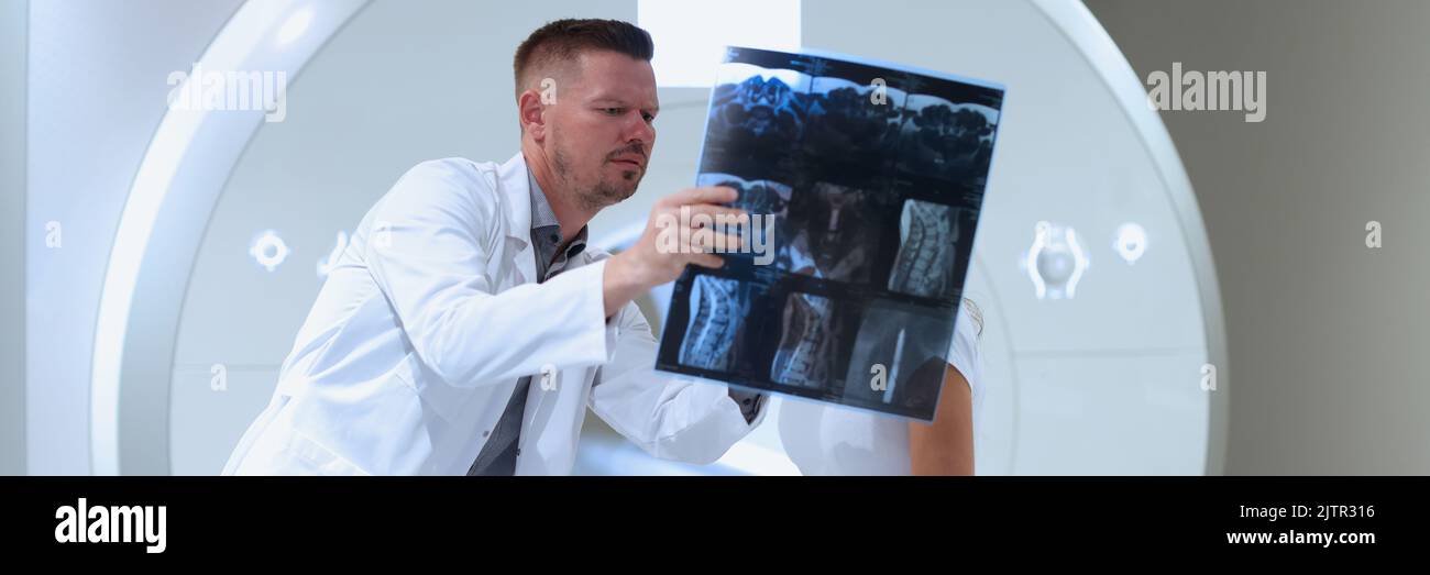 Doctor showing patient mri scan of spine in clinic Stock Photo - Alamy