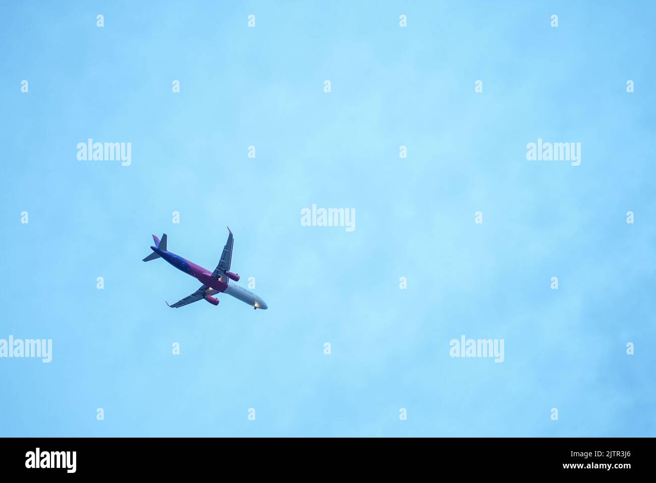 Airplane in sight line flying below clear skies Stock Photo - Alamy