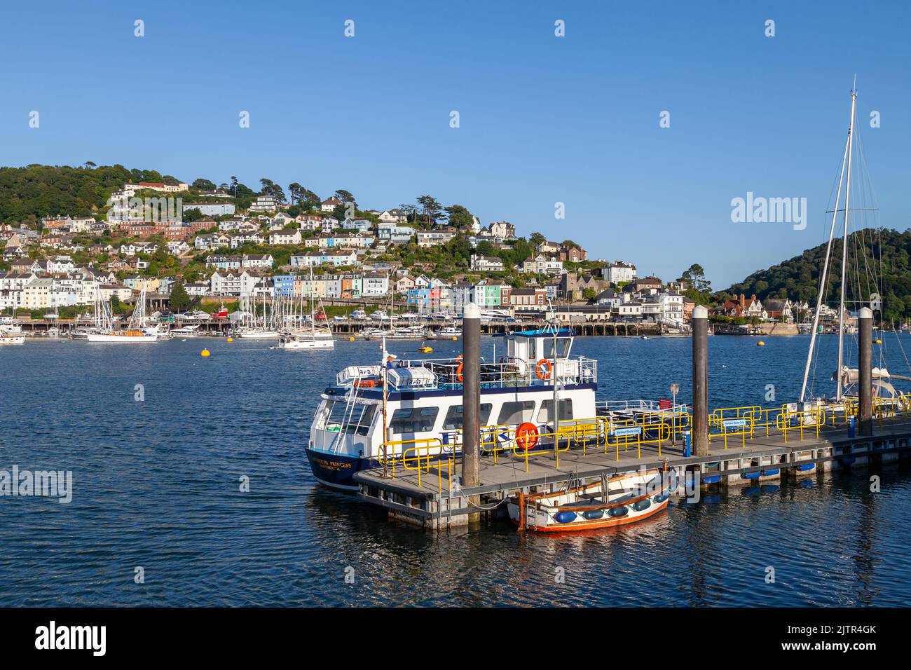 A small passenger ferry moored at a pontoon in Dartmouth harbour, Devon ...