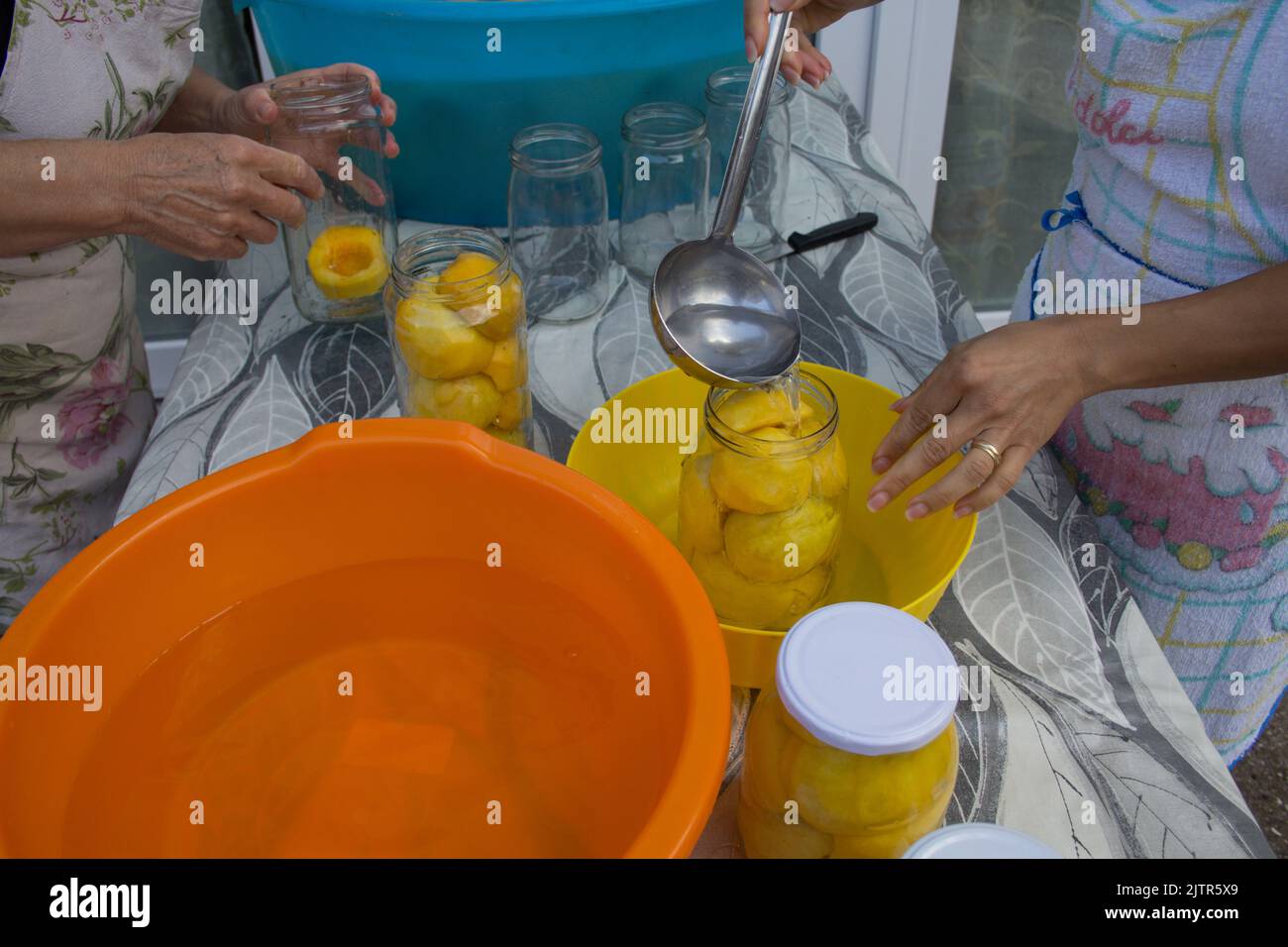 Image of two women preparing canned peaches in jars Stock Photo - Alamy