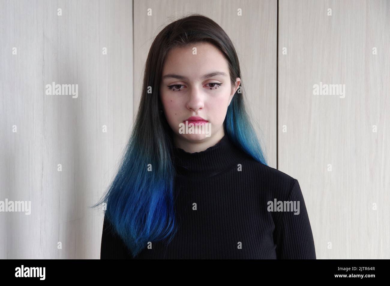 Teenage problems. Portrait of a sad upset girl with blue hair and ...