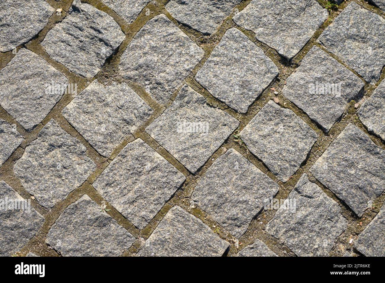 Chipped stone pavement background texture, cobbled street in sunlight ...