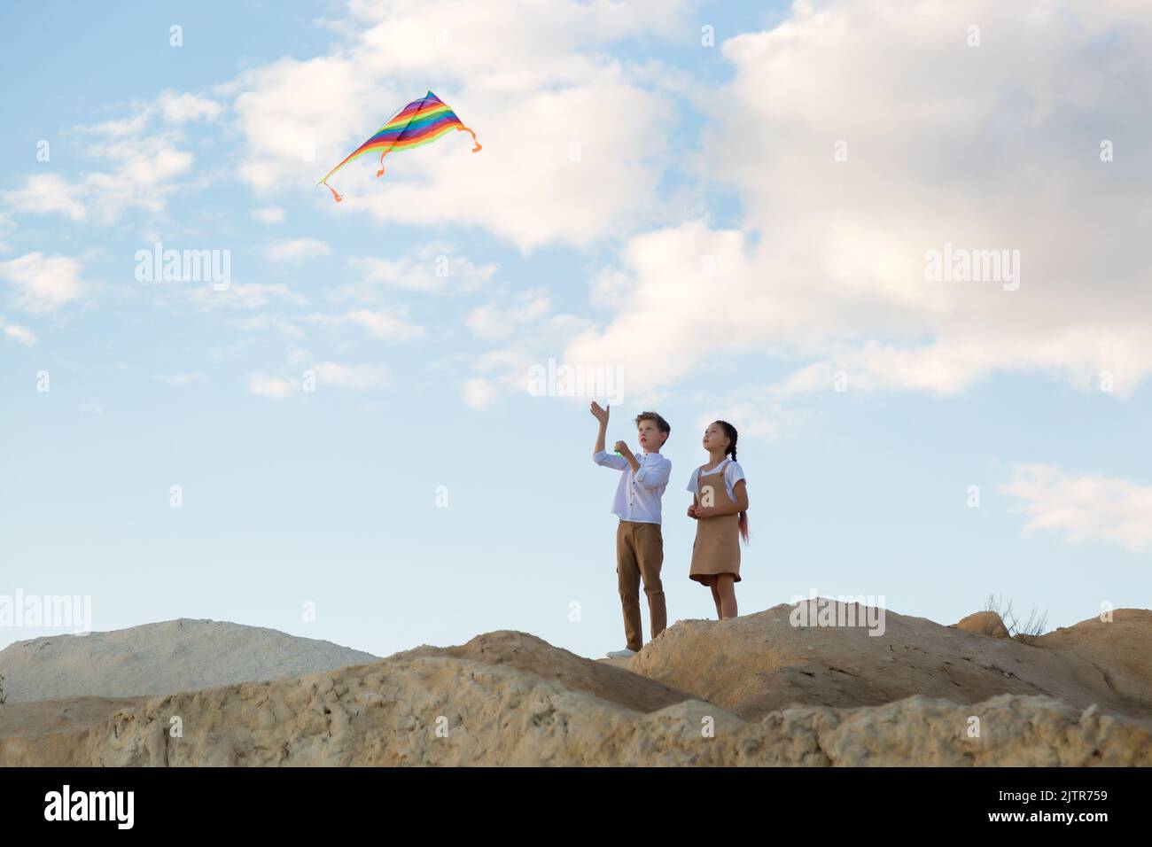 Brother and sister fly a kite into the sky high mountain Stock Photo ...