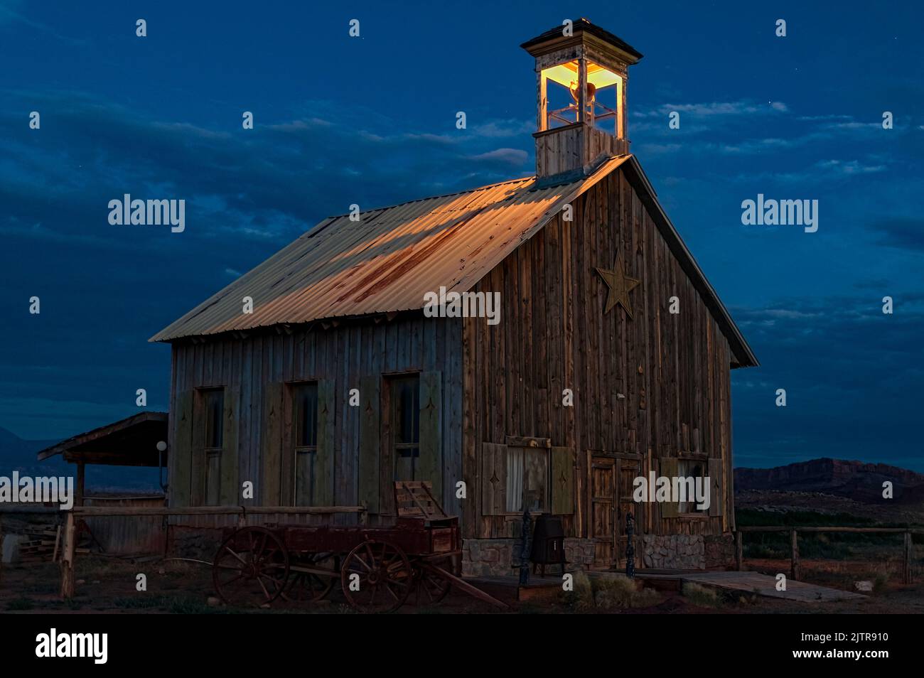 An old barn, church, building of some sorts, with it lighted bell tower ...