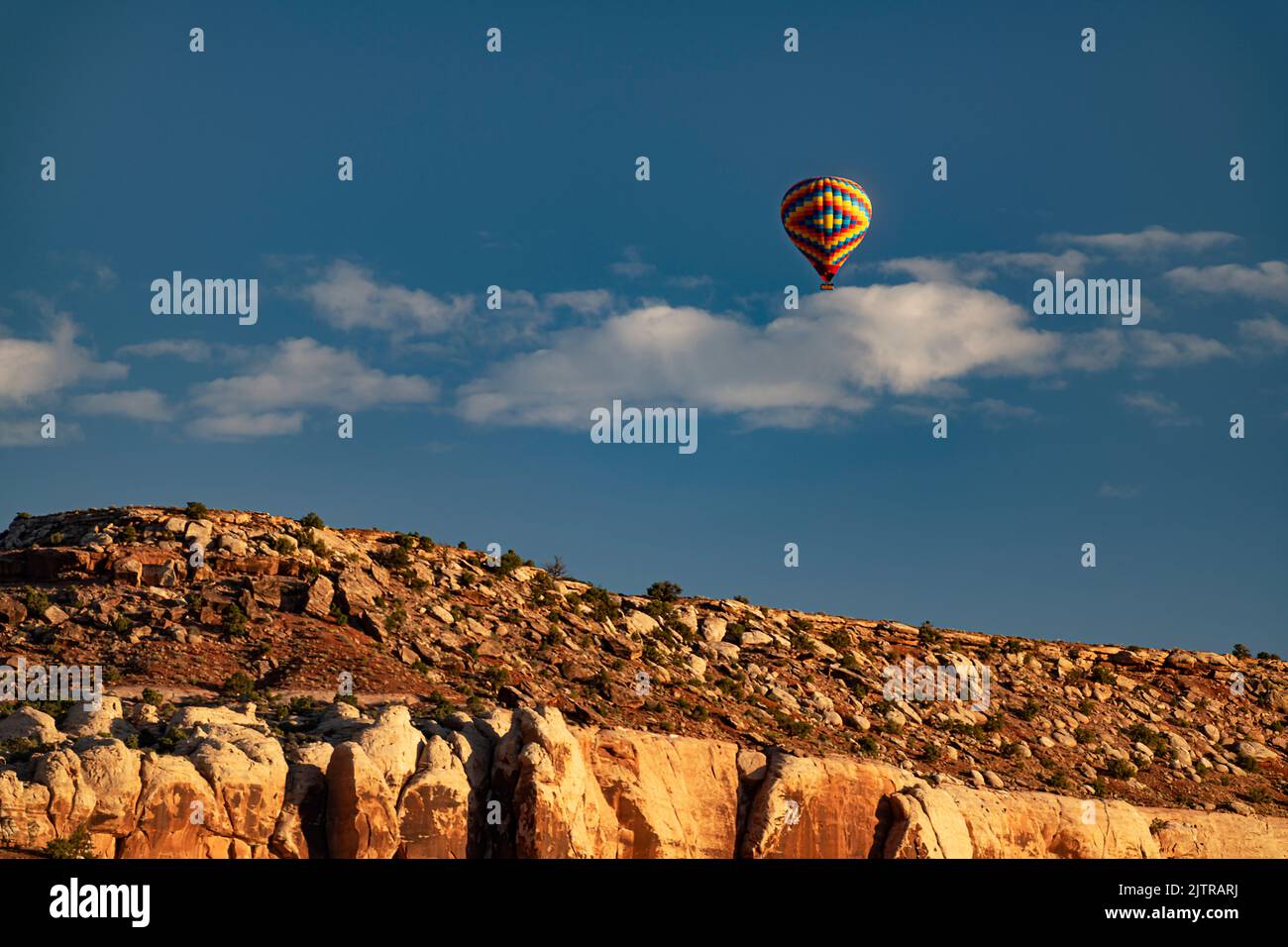 A hot air balloon flies over a mesa along Utah highway 313 in Grand ...
