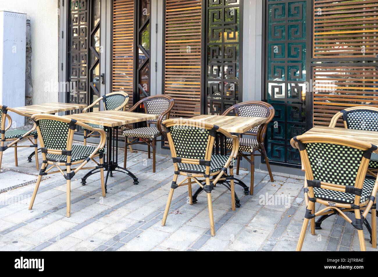 Glass tables and wicker chairs in a street cafe Stock Photo - Alamy