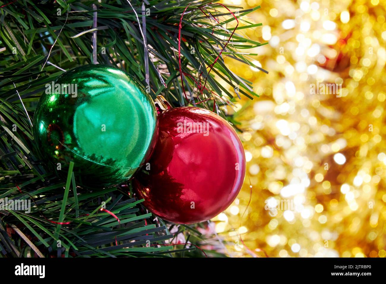 Christmas tree branch closeup with red and green balls and golden ...
