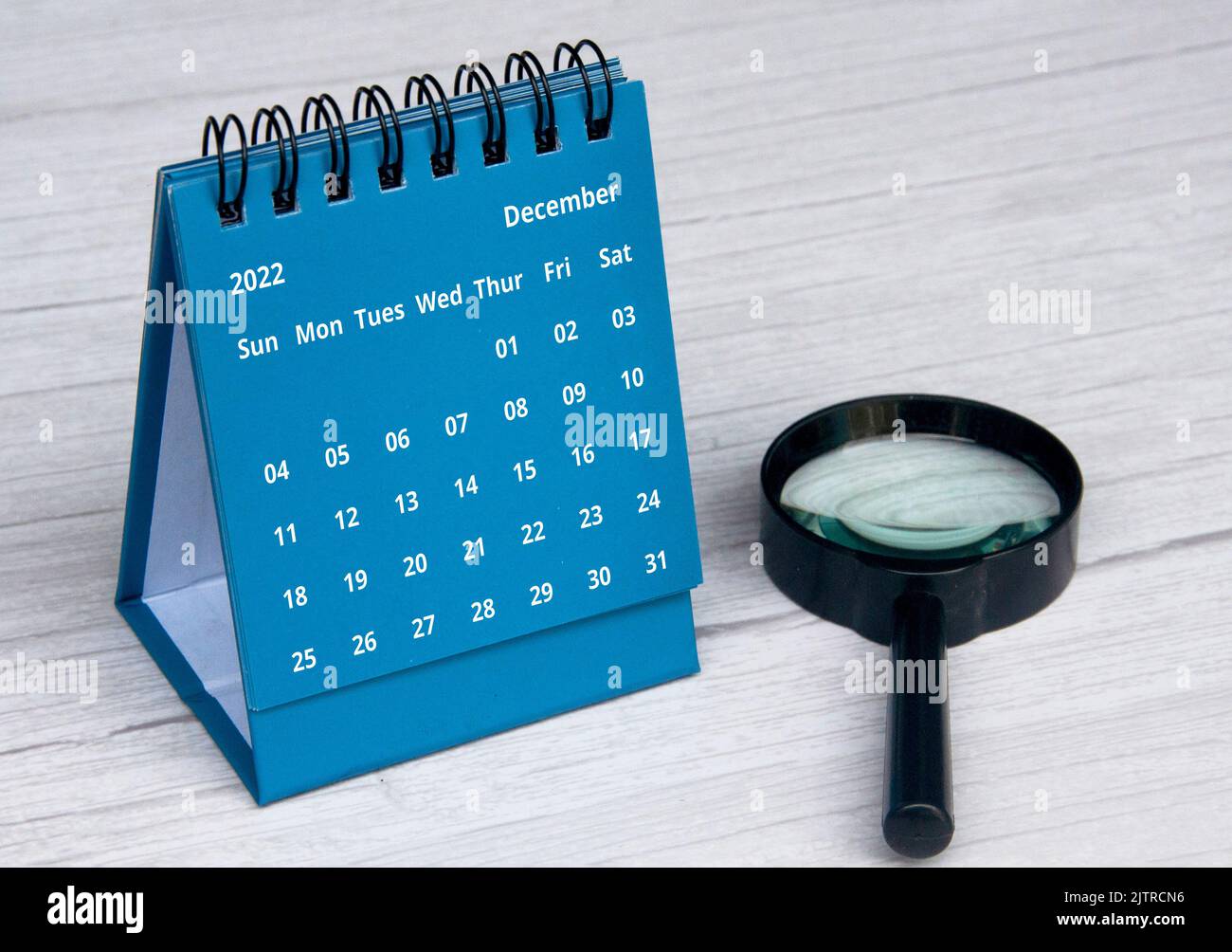 December 2022 blue color desk calendar on wooden desk with copy space ...