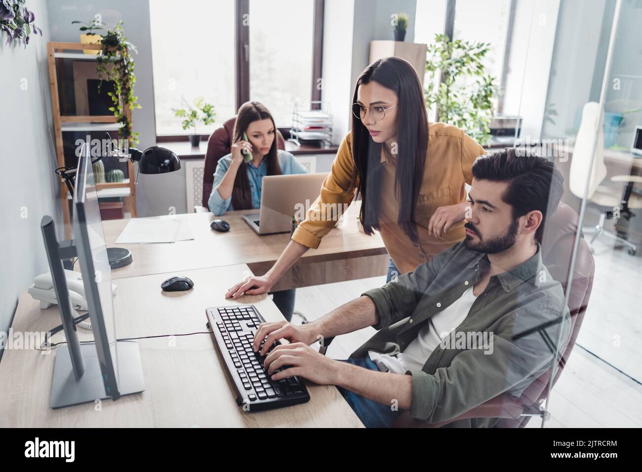 Photo of three successful intelligent employee browsing computer ...