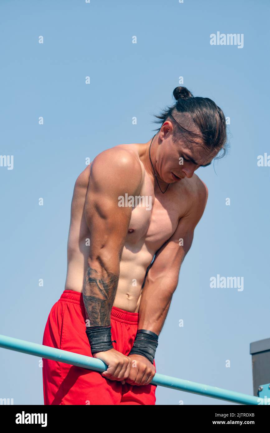 Pull-ups on the bar. Young strong muscular man doing strength exercises ...