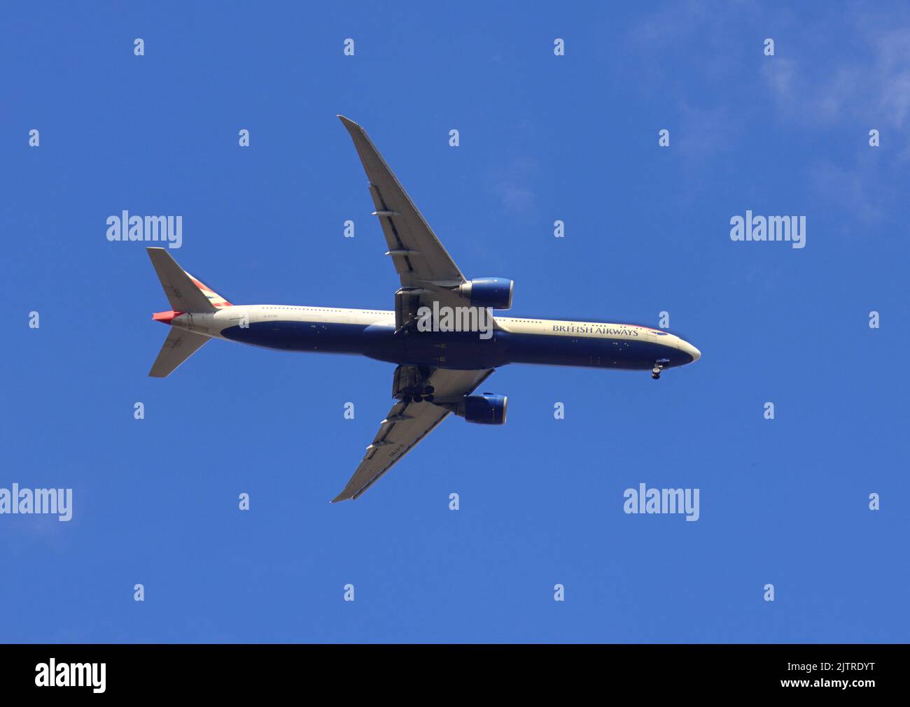 Passenger Jet Aeroplane flying directly above in a bright blue sky ...