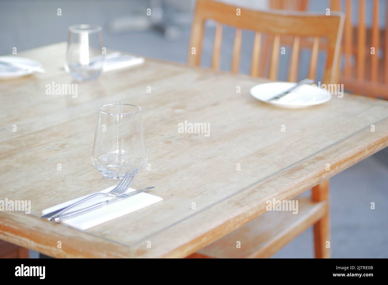 cutlery and empty plate on table against cafe background Stock Photo ...